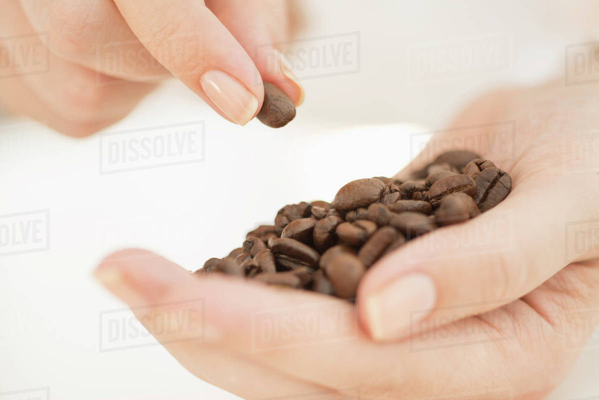 Coffee beans on woman's hand - Royalty-free Stock Photo | Dissolve