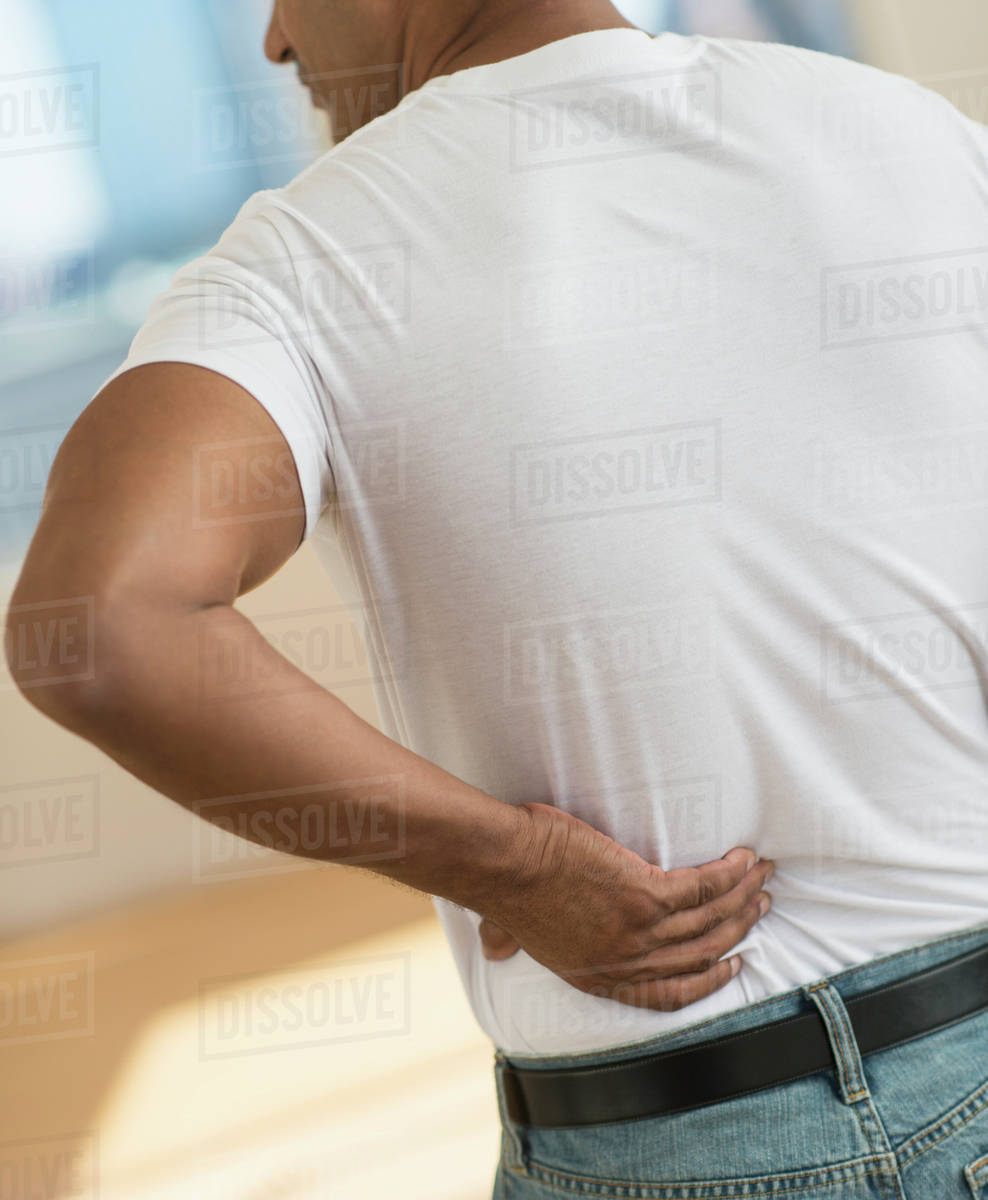 Man massaging his back - Royalty-free Stock Photo | Dissolve