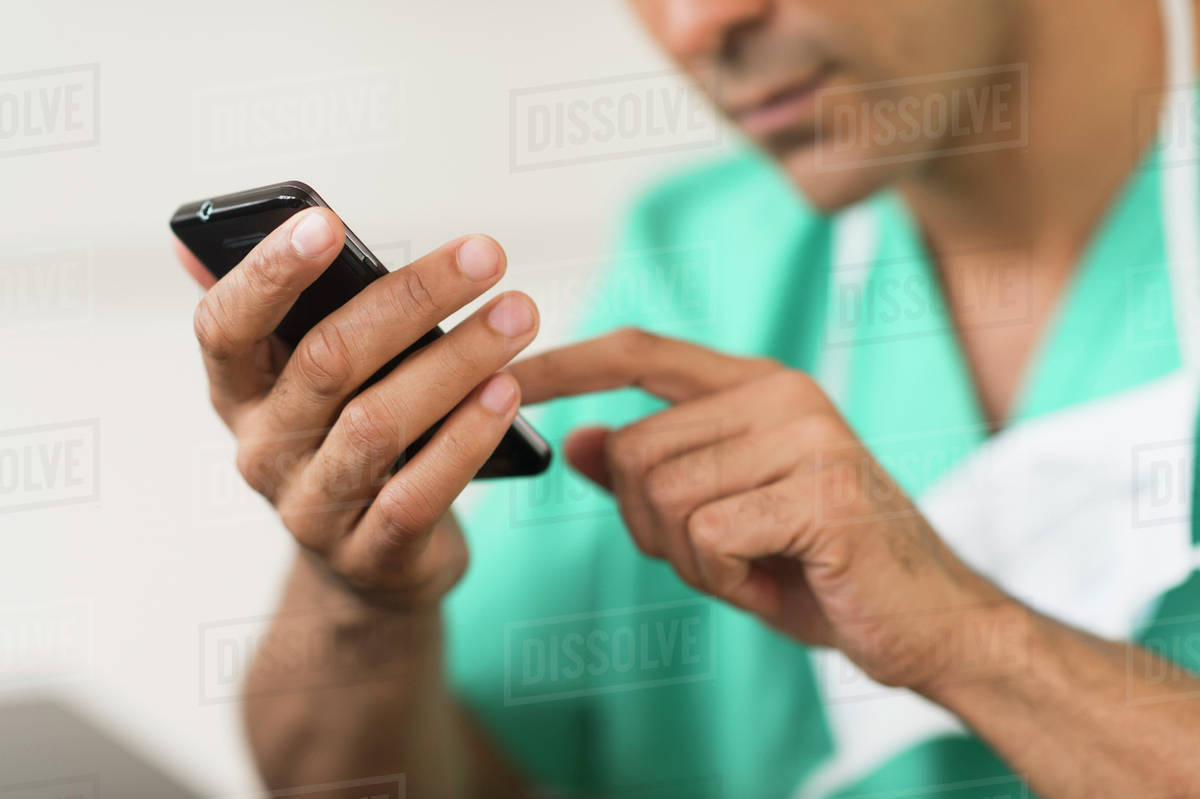 Close up of male surgeon using mobile phone in hospital - Stock Photo ...