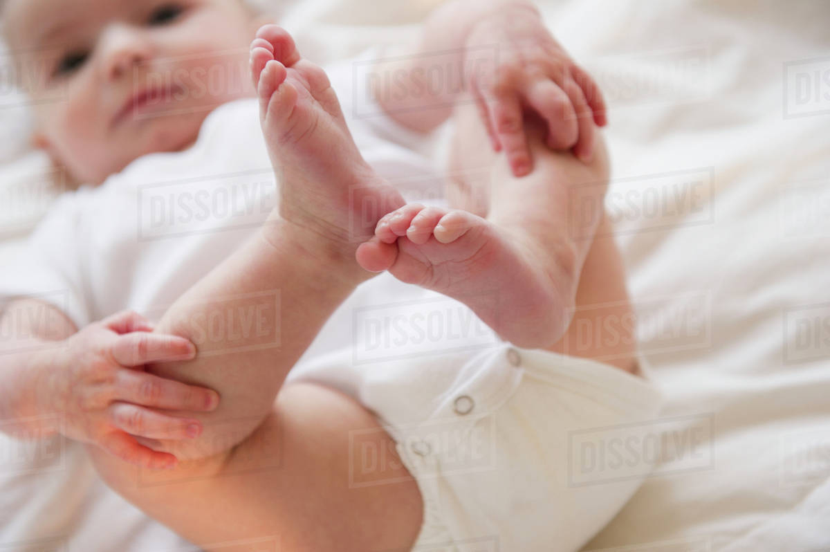 Baby boy (2-5) touching legs - Royalty-free Stock Photo | Dissolve