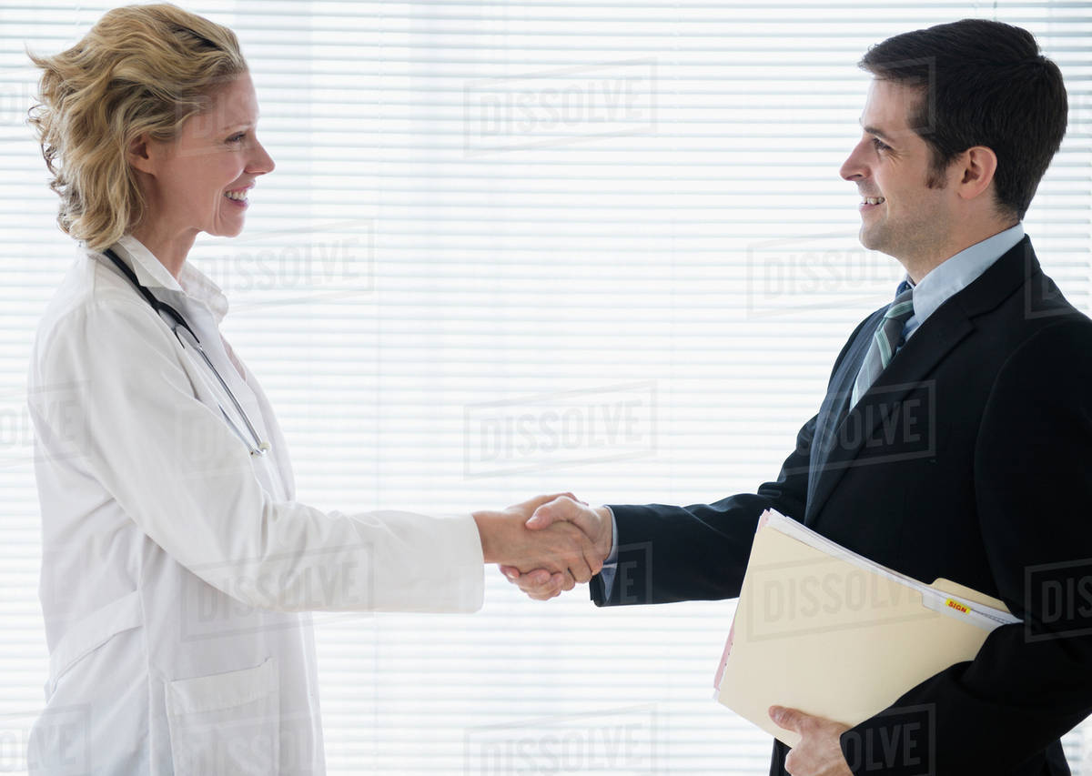 Female doctor greeting office worker - Royalty-free Stock Photo | Dissolve