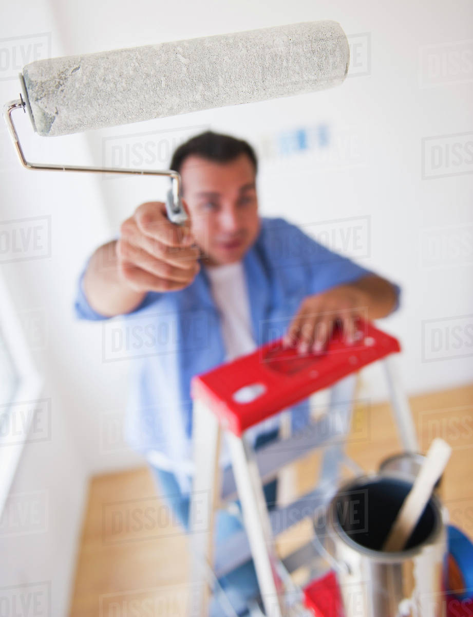 Man standing on ladder with paint roller - Royalty-free Stock Photo ...