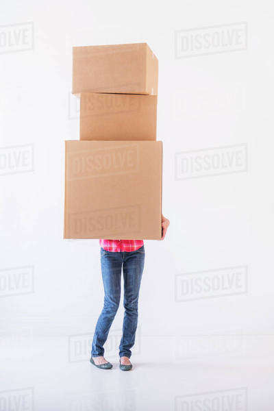Studio shot of young woman carrying stack of boxes - Royalty-free Stock ...