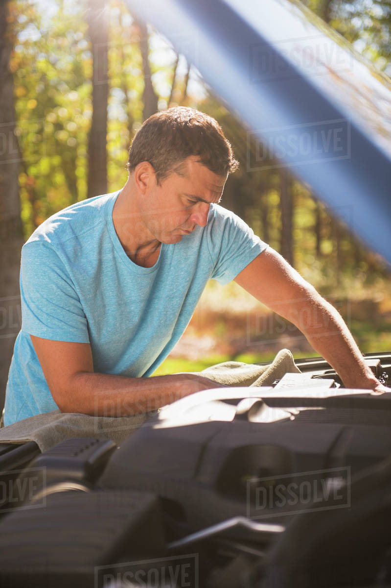 Man repairing car at roadside - Royalty-free Stock Photo | Dissolve