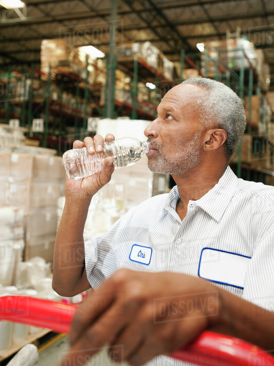 Warehouse worker drinking water - Stock Photo - Dissolve