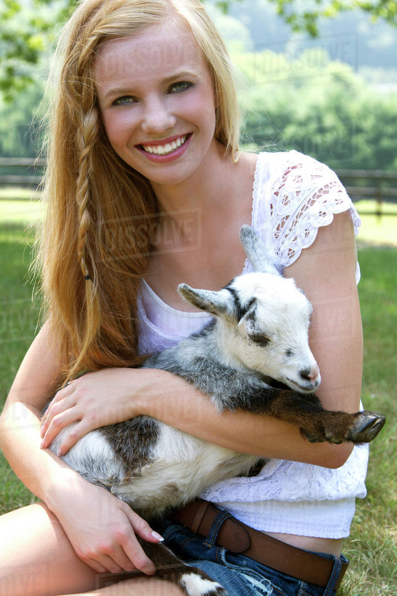 Teenage girl (14-15) holding small goat - Royalty-free Stock Photo ...