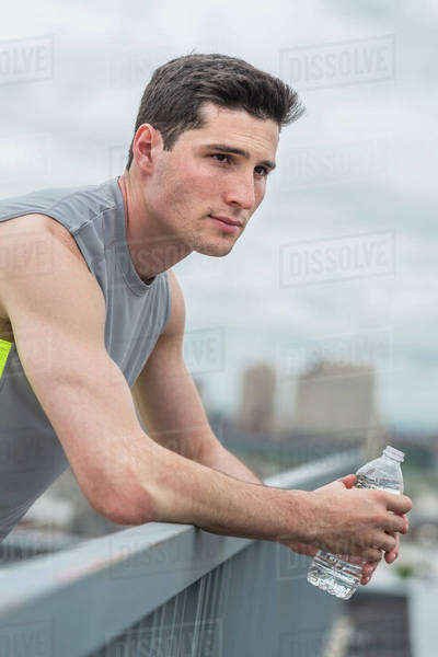 Athlete leaning against railing - Royalty-free Stock Photo | Dissolve