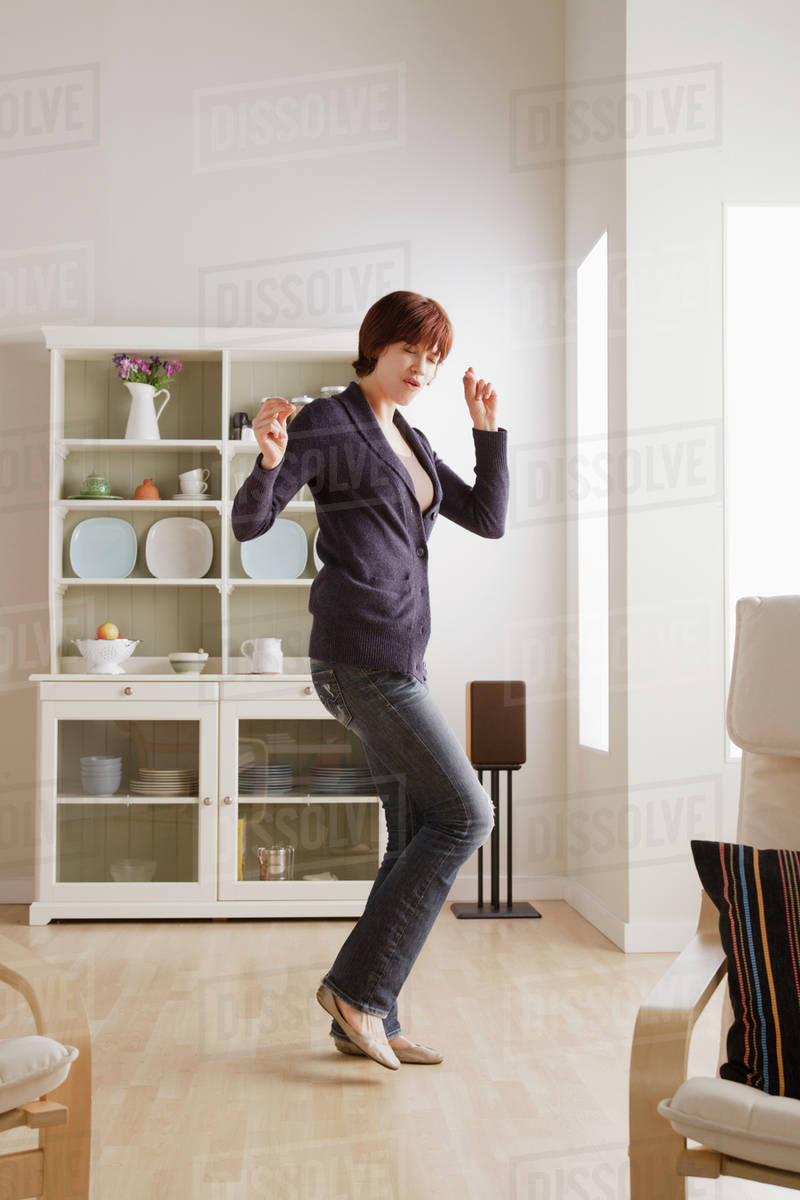 Young woman dancing at home - Stock Photo - Dissolve