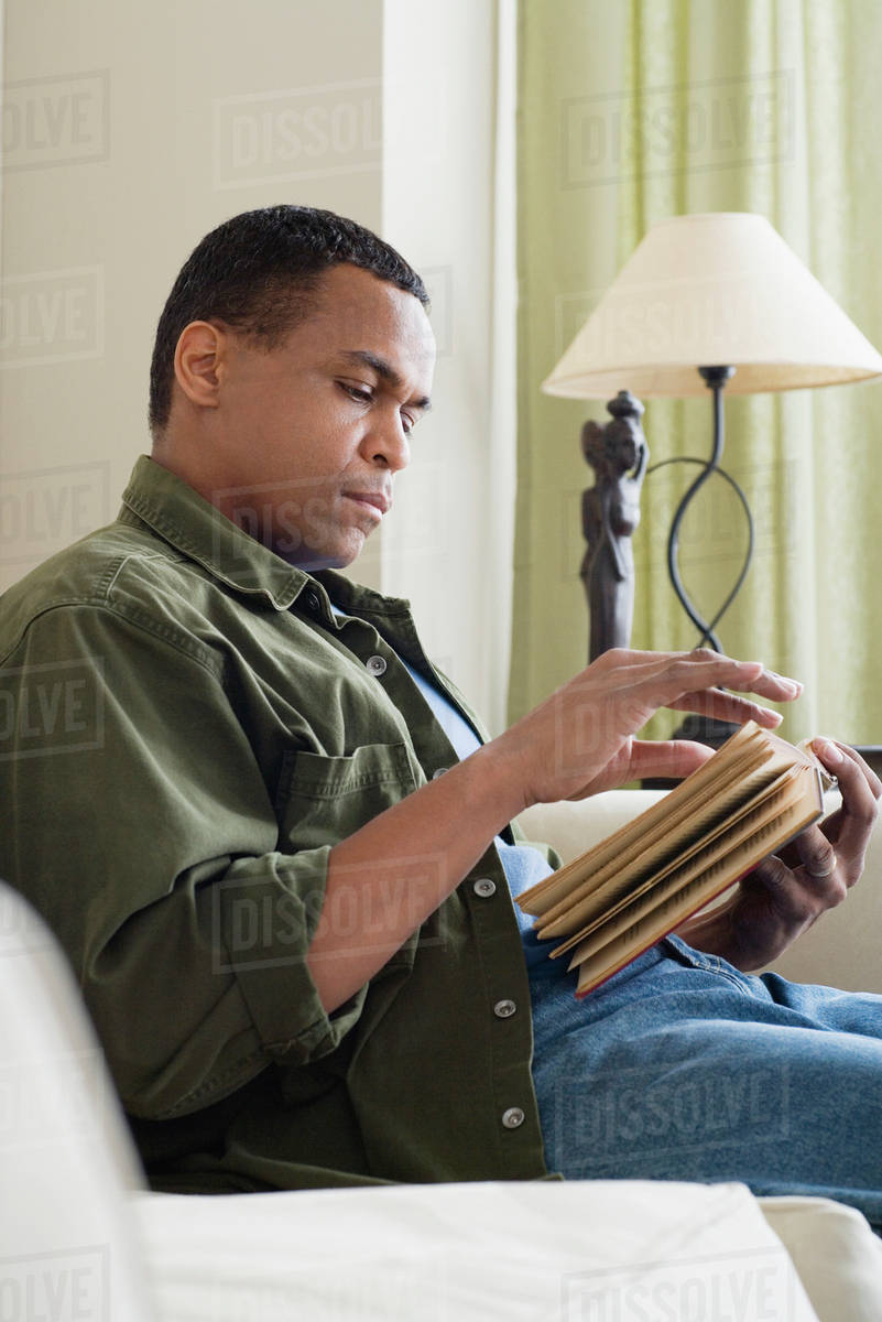 Man reading book at home - Royalty-free Stock Photo | Dissolve