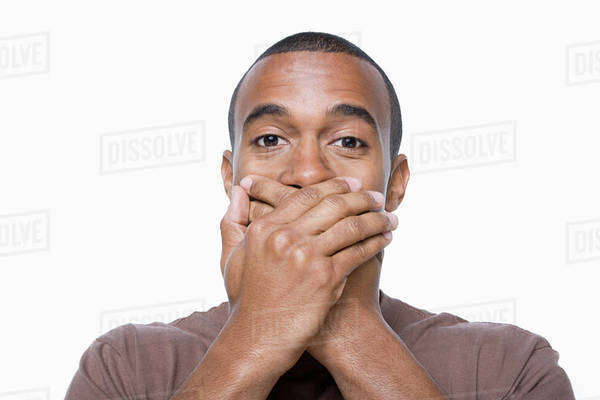 Studio portrait of young man with hands on his mouth - Stock Photo ...