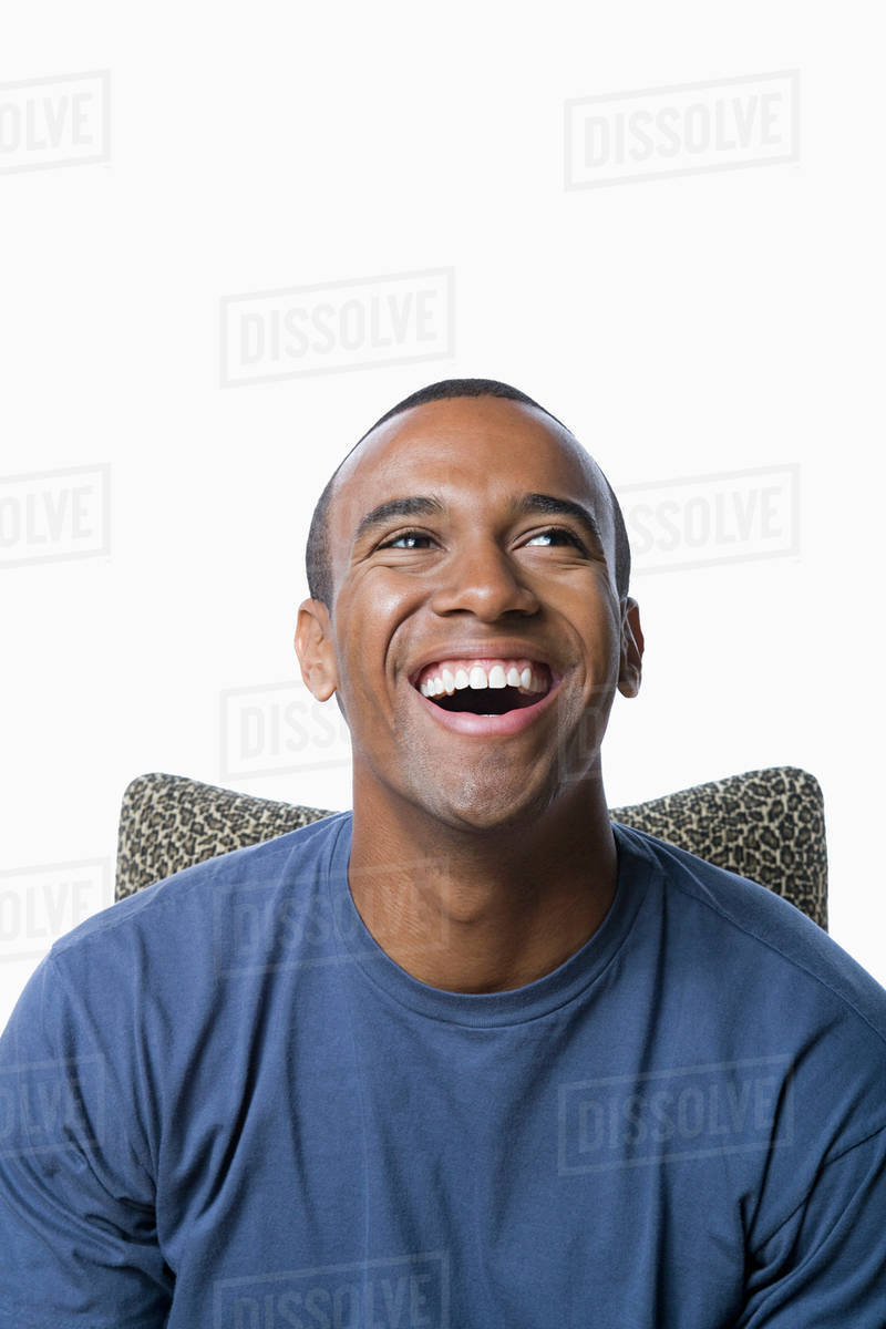 Studio portrait of young man laughing - Royalty-free Stock Photo | Dissolve