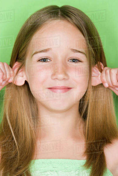 Studio shot portrait of teenage girl pulling her ears, close-up ...