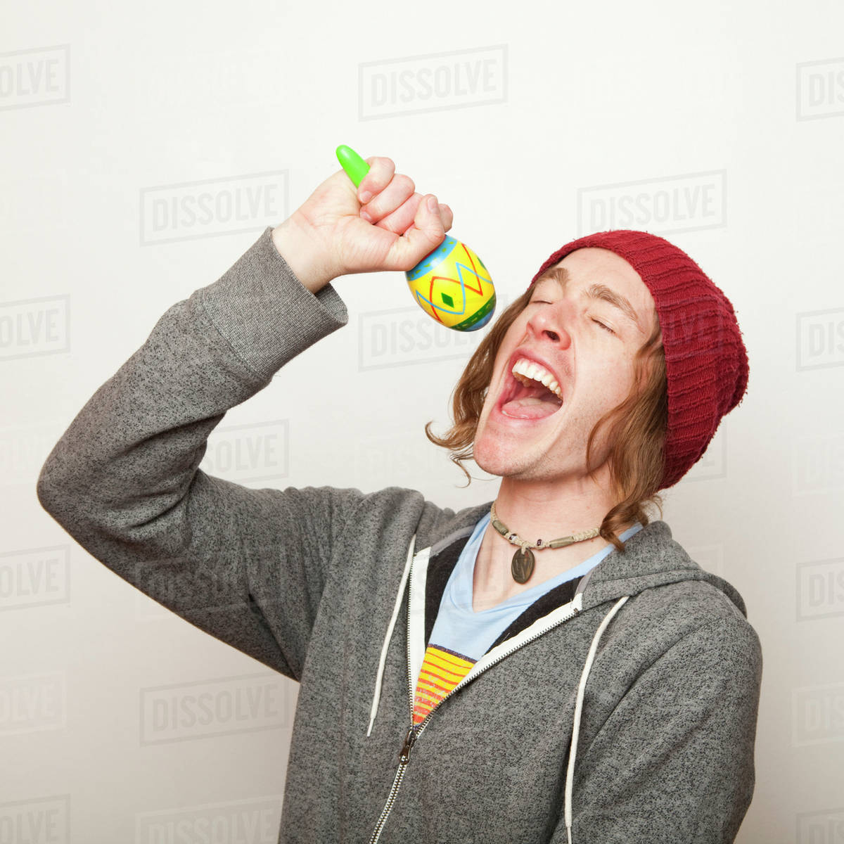 Studio Shot of young man pretending to sing - Stock Photo - Dissolve