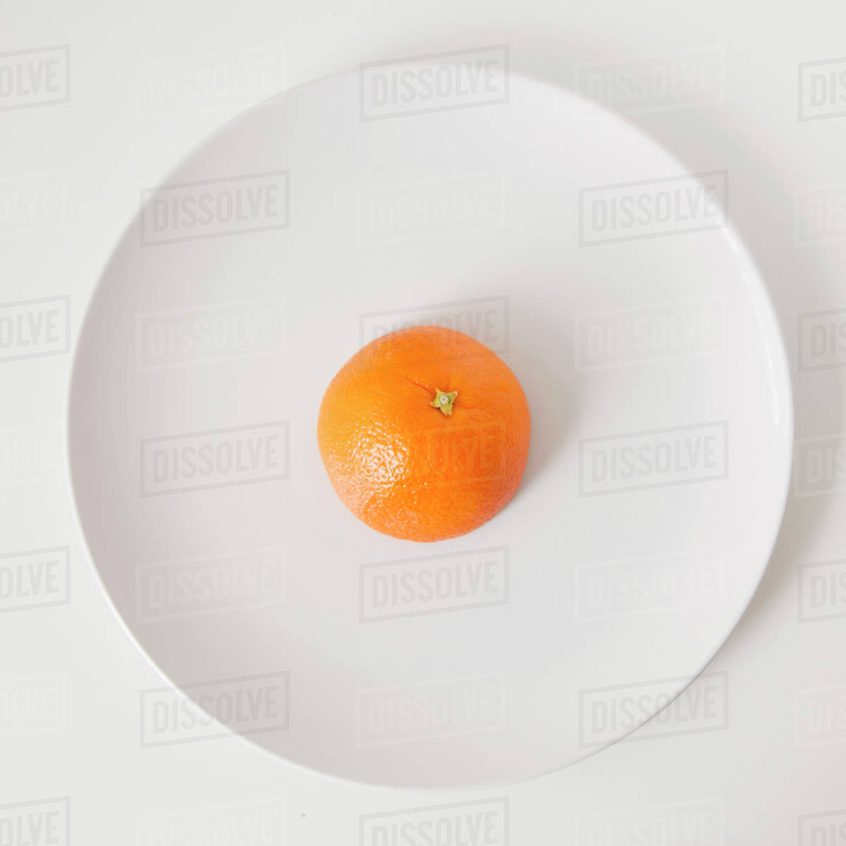 Orange on plate, studio shot - Royalty-free Stock Photo | Dissolve