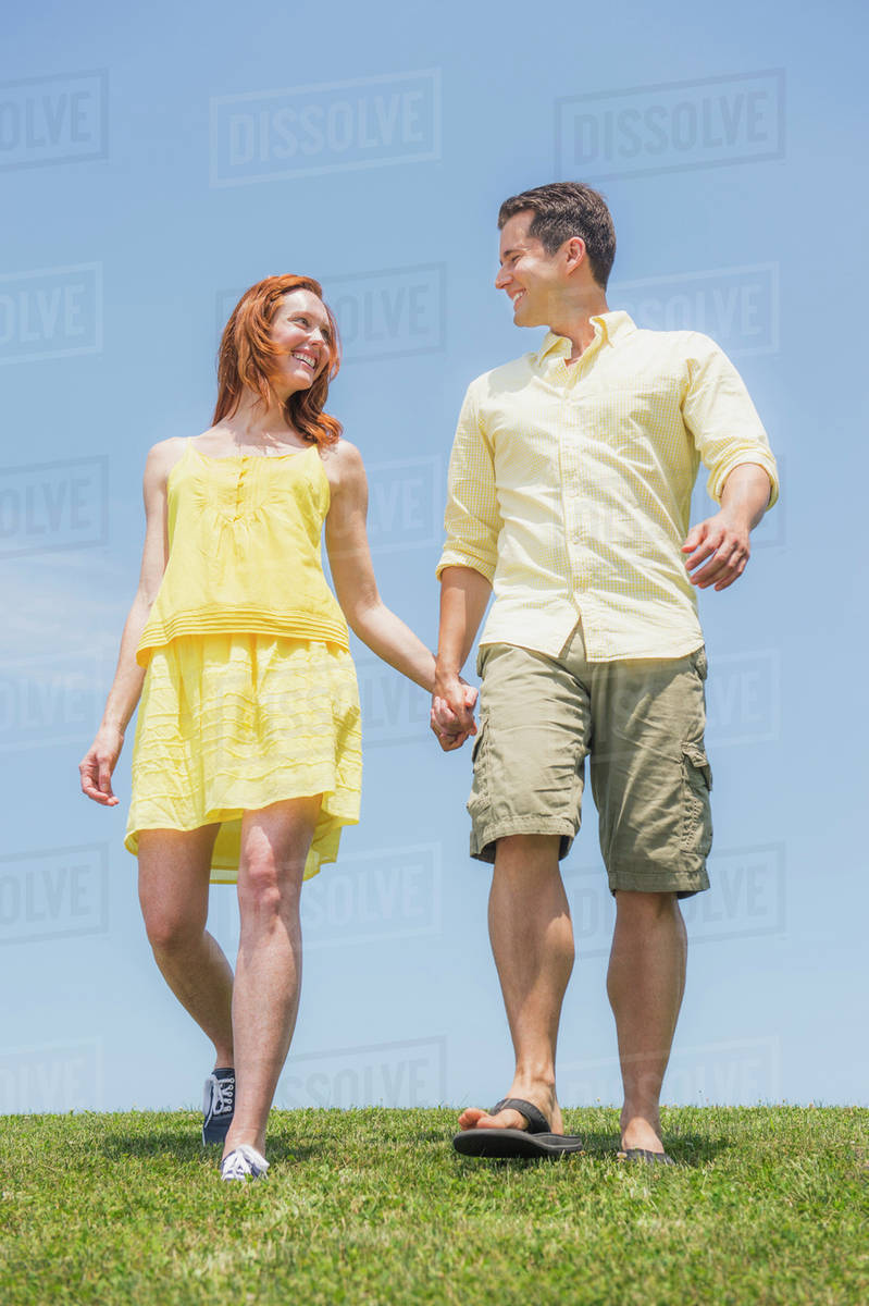 Couple walking on meadow - Royalty-free Stock Photo | Dissolve