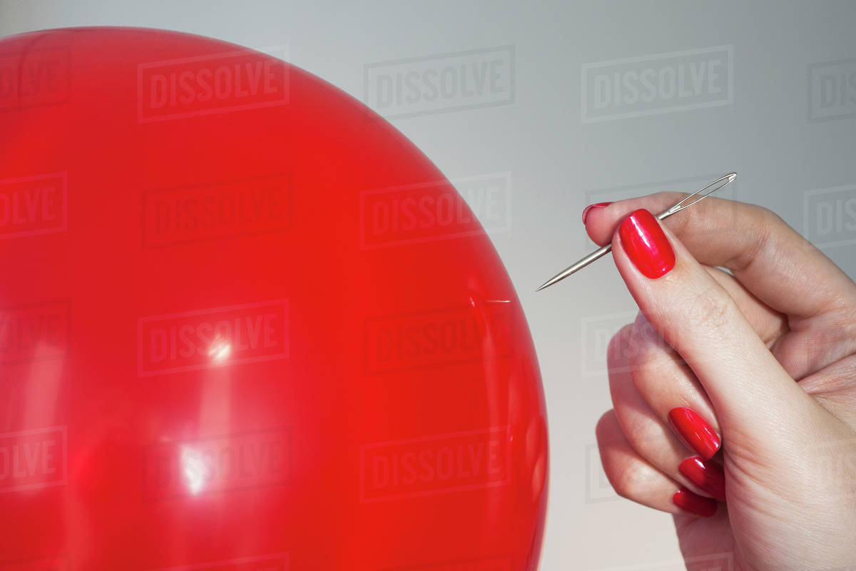 Close up of red balloon and woman's hand holding needle - Royalty-free ...
