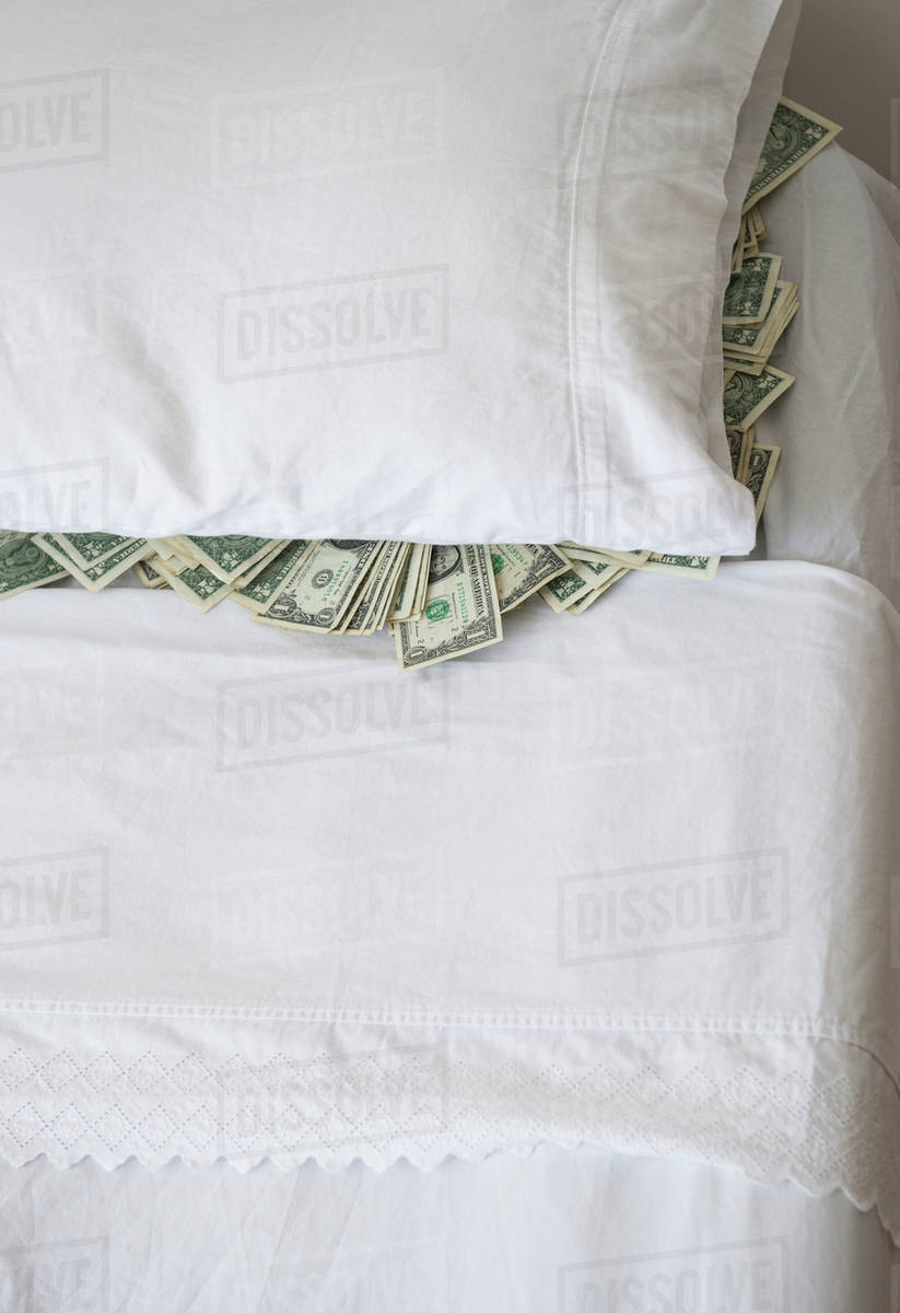 Dollar bills stacked under pillow - Royalty-free Stock Photo | Dissolve