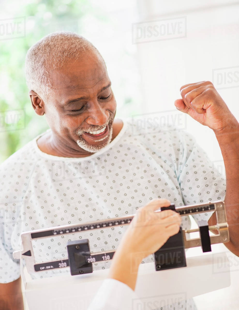 Happy man on weight scale - Royalty-free Stock Photo | Dissolve
