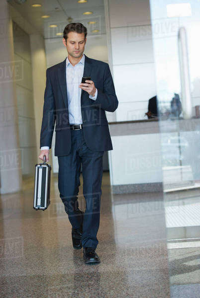 Businessman leaving office and using PDA - Royalty-free Stock Photo ...