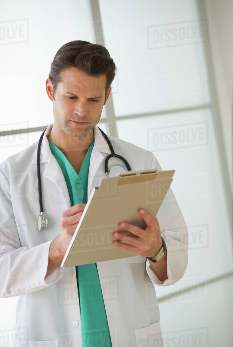 Doctor filling medical documents - Stock Photo - Dissolve