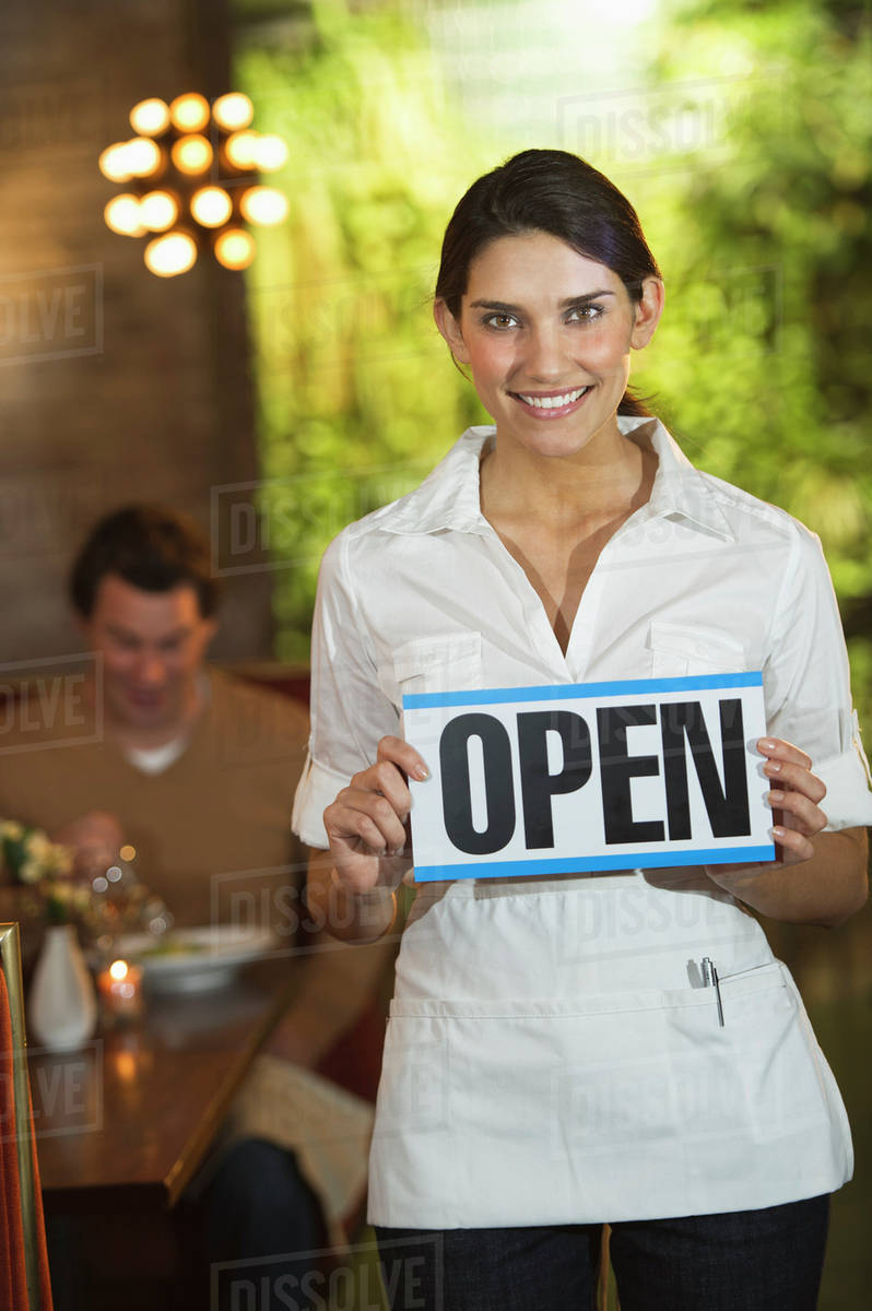 Smiling waitress in restaurant showing "open sign" - Royalty-free Stock ...