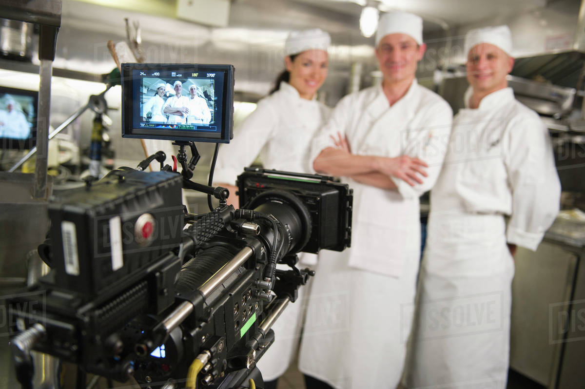Three chefs posing in kitchen, camera in foreground - Royalty-free ...