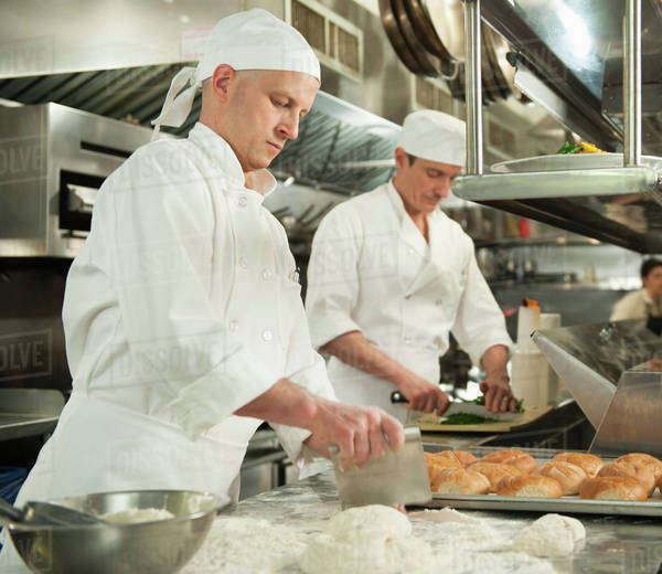 Chef cutting pastry to make rolls - Stock Photo - Dissolve