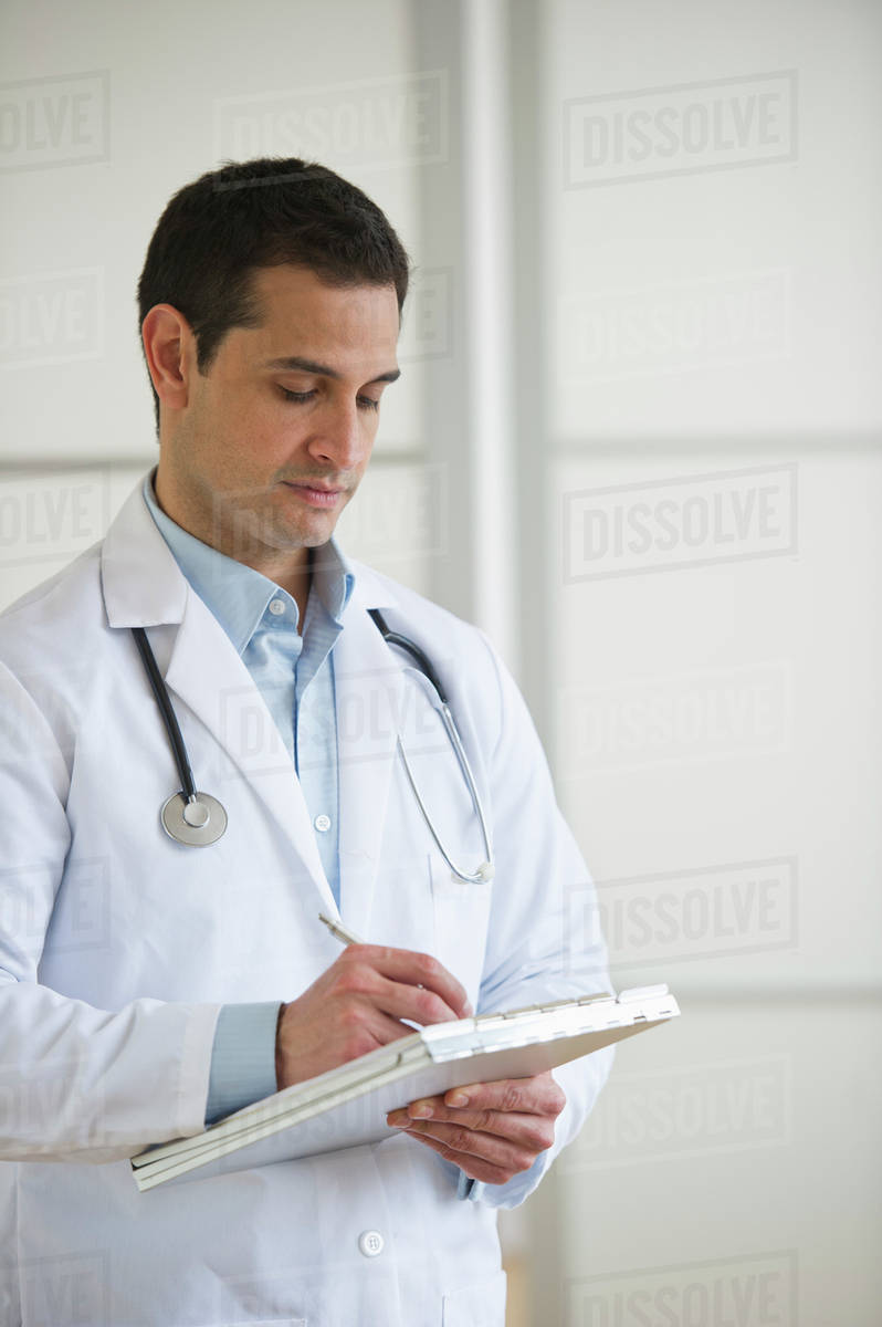 Doctor writing in notepad - Royalty-free Stock Photo | Dissolve