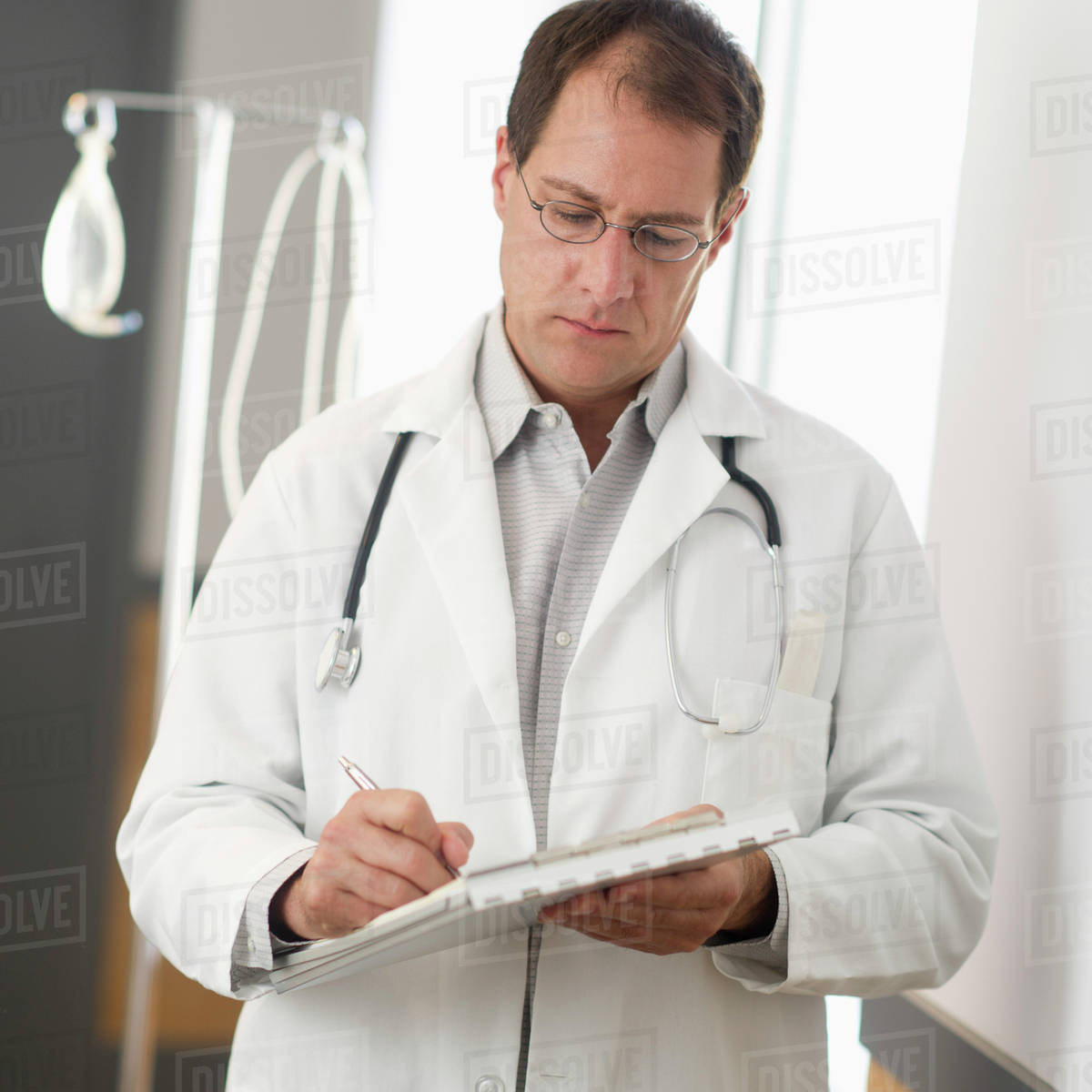 Doctor writing in clipboard - Royalty-free Stock Photo | Dissolve