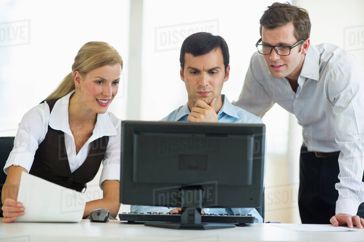 Business team looking at computer - Royalty-free Stock Photo | Dissolve