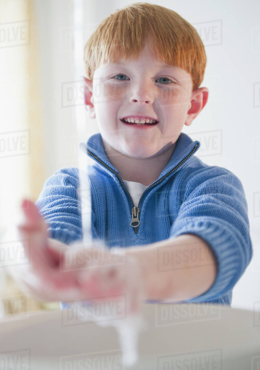 Portrait of boy (8-9) washing hands - Royalty-free Stock Photo | Dissolve