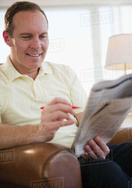 Man reading job adverts in newspaper - Royalty-free Stock Photo | Dissolve
