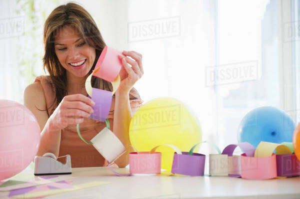 Woman preparing paper chain - Stock Photo - Dissolve
