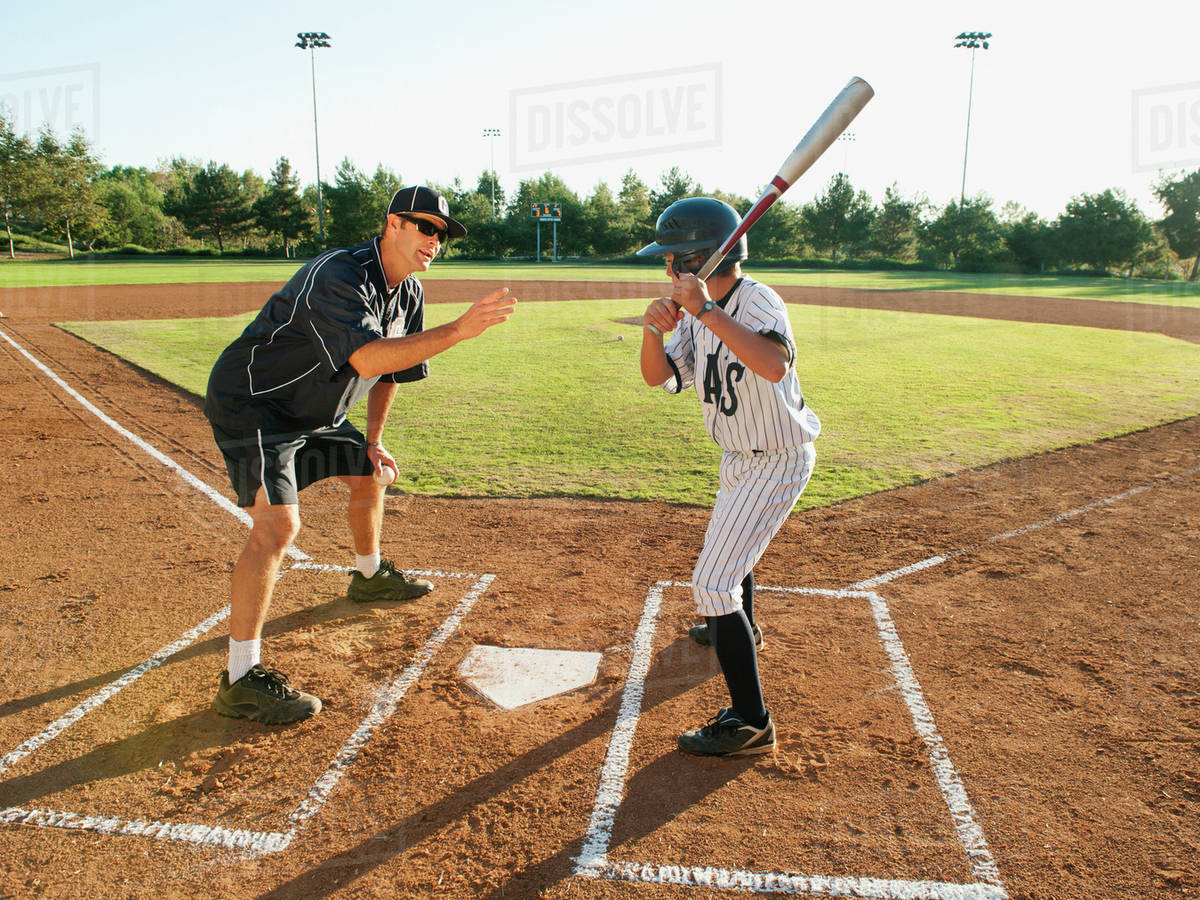 Baseball coach and boy (10-11) standing on baseball diamond - Royalty ...