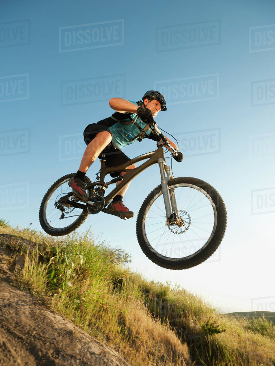 USA, California, Laguna Beach, Mountain biker jumping downhill on his ...