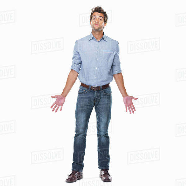 Studio shot of young man with chin up and palms out standing on white ...