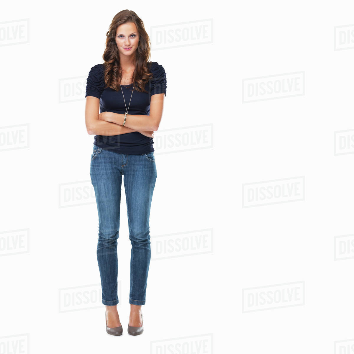 Studio shot of young woman standing with hands folded - Royalty-free ...
