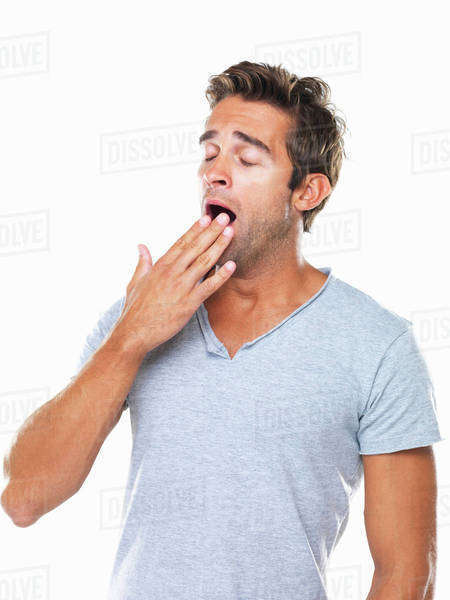 Studio portrait of young man yawning - Royalty-free Stock Photo | Dissolve
