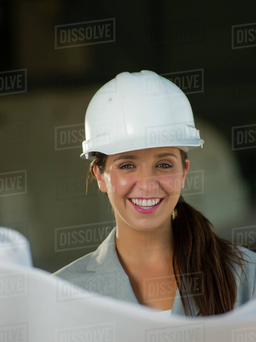 Woman wearing hardhat reading blueprint - Royalty-free Stock Photo ...