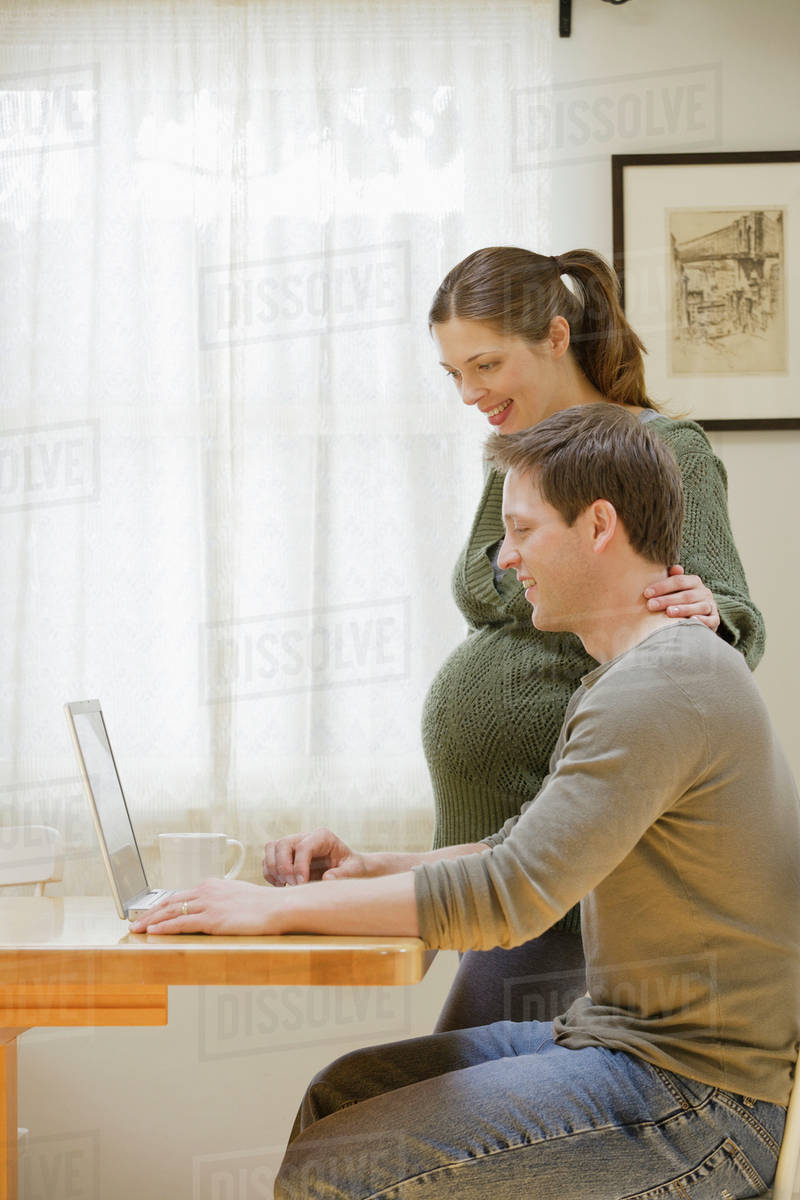 Couple using laptop at home - Royalty-free Stock Photo | Dissolve