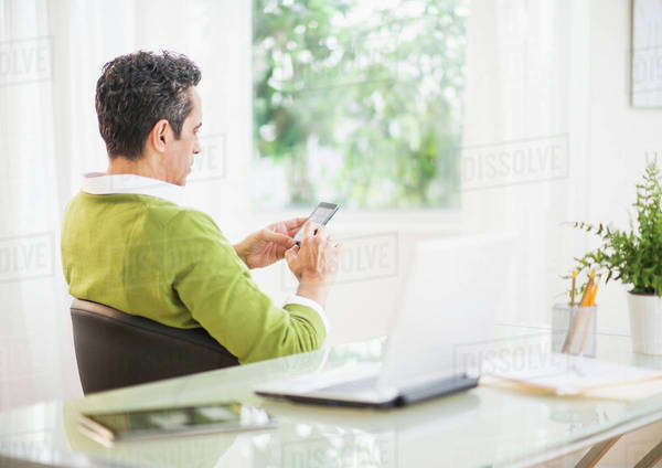 Side view of man using mobile phone - Stock Photo - Dissolve