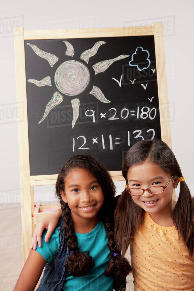 Studio portrait of two girls (8-9) in front of blackboard - Royalty ...