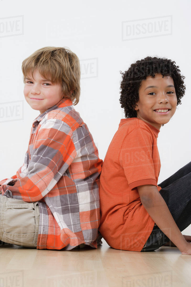 Studio portrait of two boys (8-9) sitting back to back - Royalty-free ...