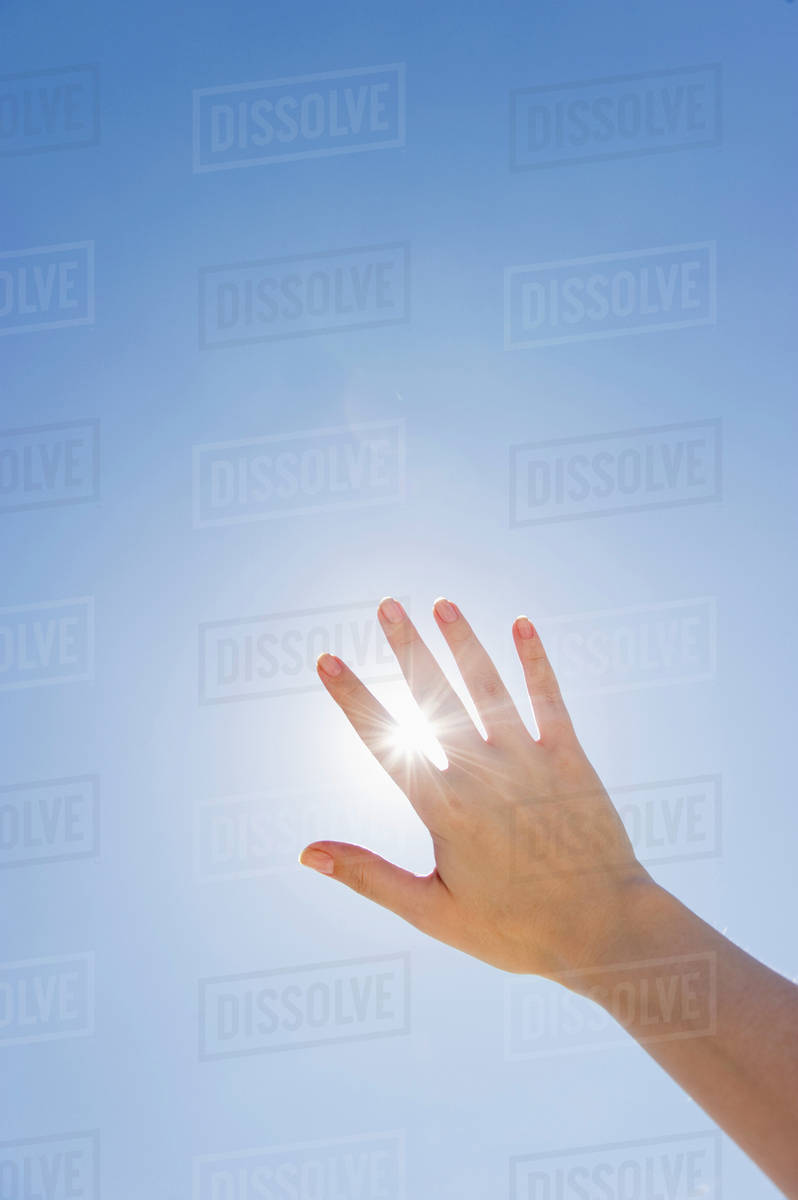 Hand held up in front of sunshine - Royalty-free Stock Photo | Dissolve