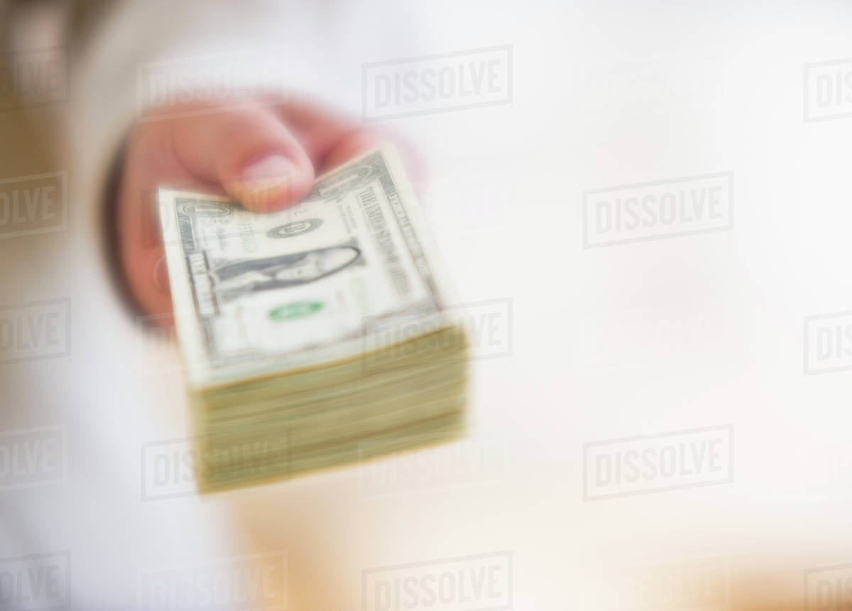 Hand holding stack of money - Stock Photo - Dissolve