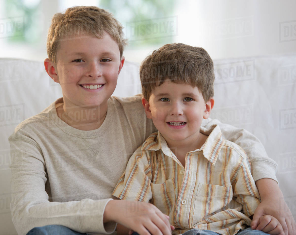 Brothers sitting on couch together - Stock Photo - Dissolve