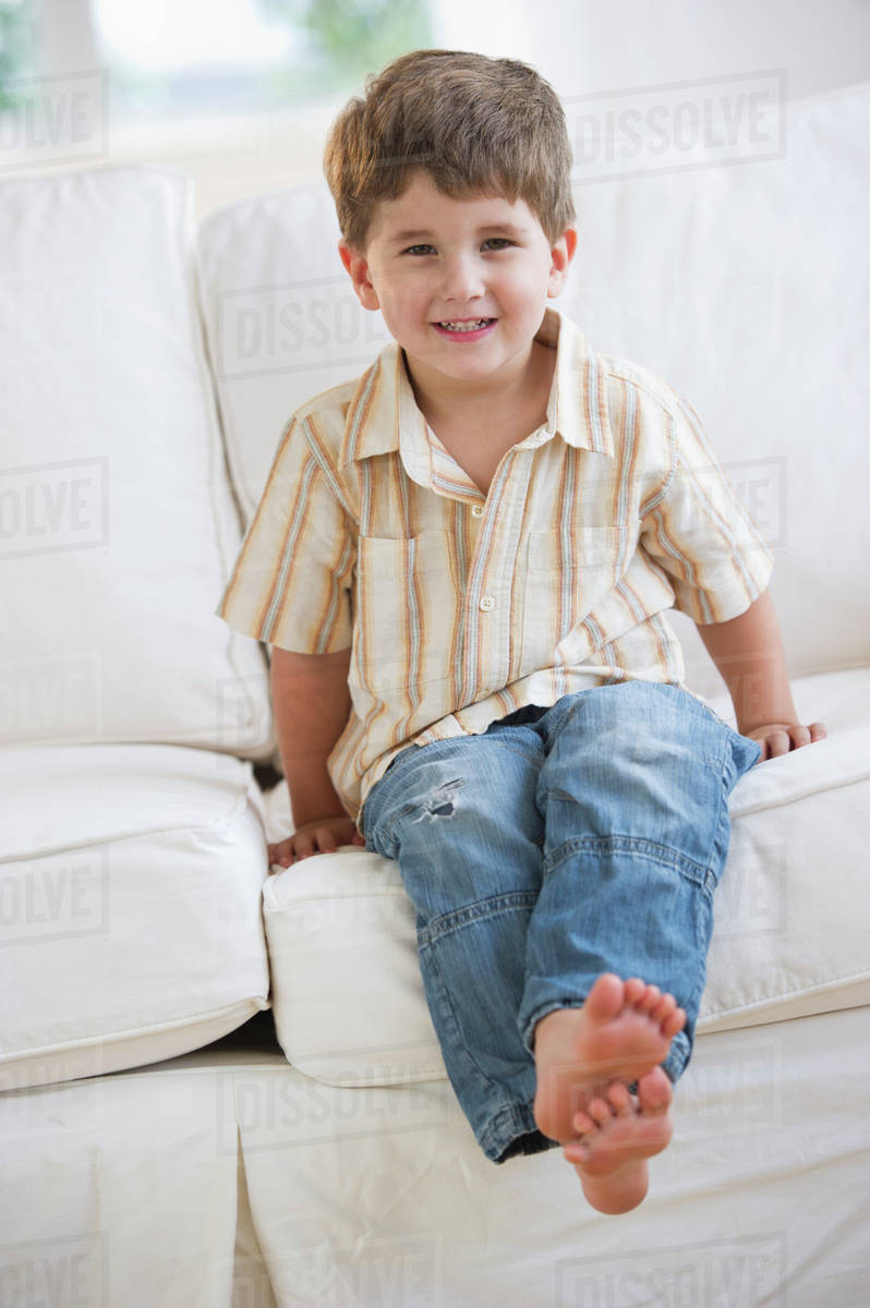 Young boy sitting on couch - Royalty-free Stock Photo | Dissolve
