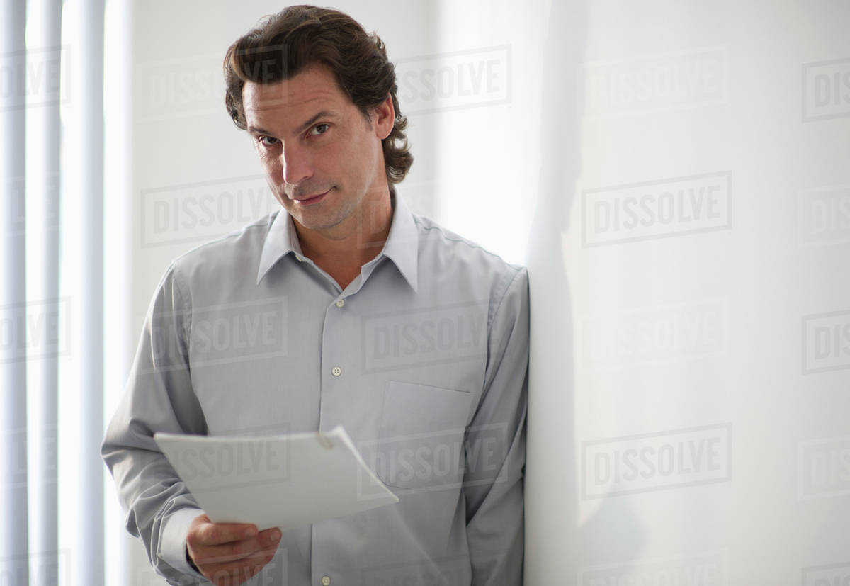 Man in office holding document - Royalty-free Stock Photo | Dissolve