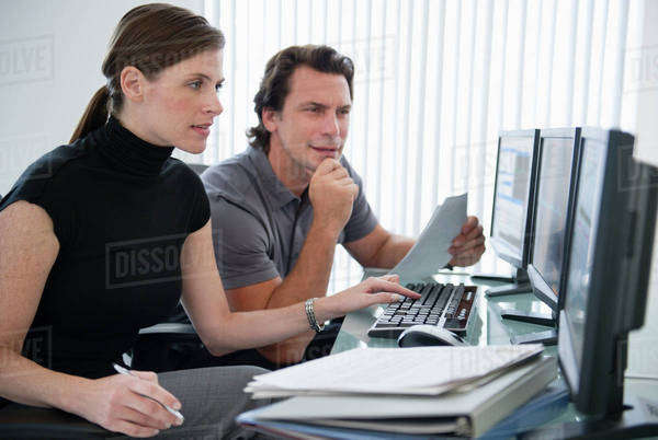 Man and woman working with computers - Royalty-free Stock Photo | Dissolve