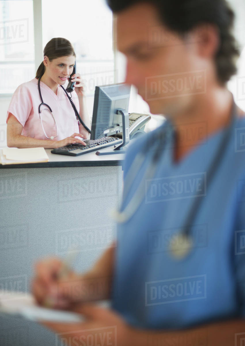 Doctor writing documentation in hospital - Stock Photo - Dissolve